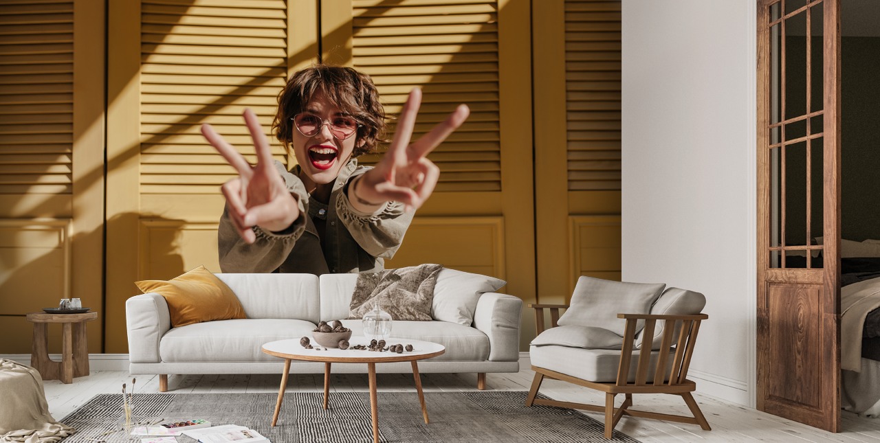 Good-humored woman with red lips showing peace sign on yellow ...